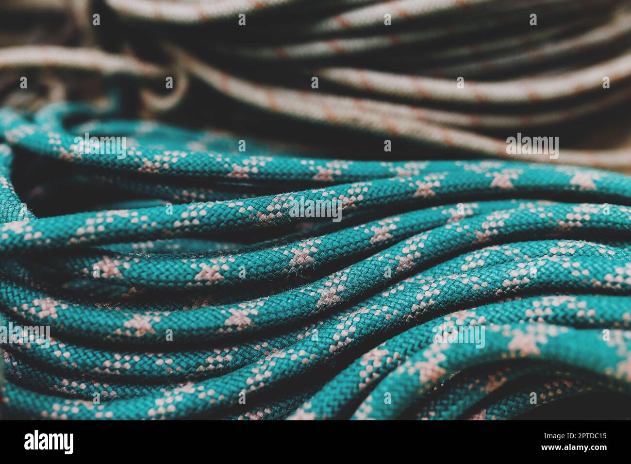 Green white nylon rope is coiled in a pile at a fishing port. Stack of ...