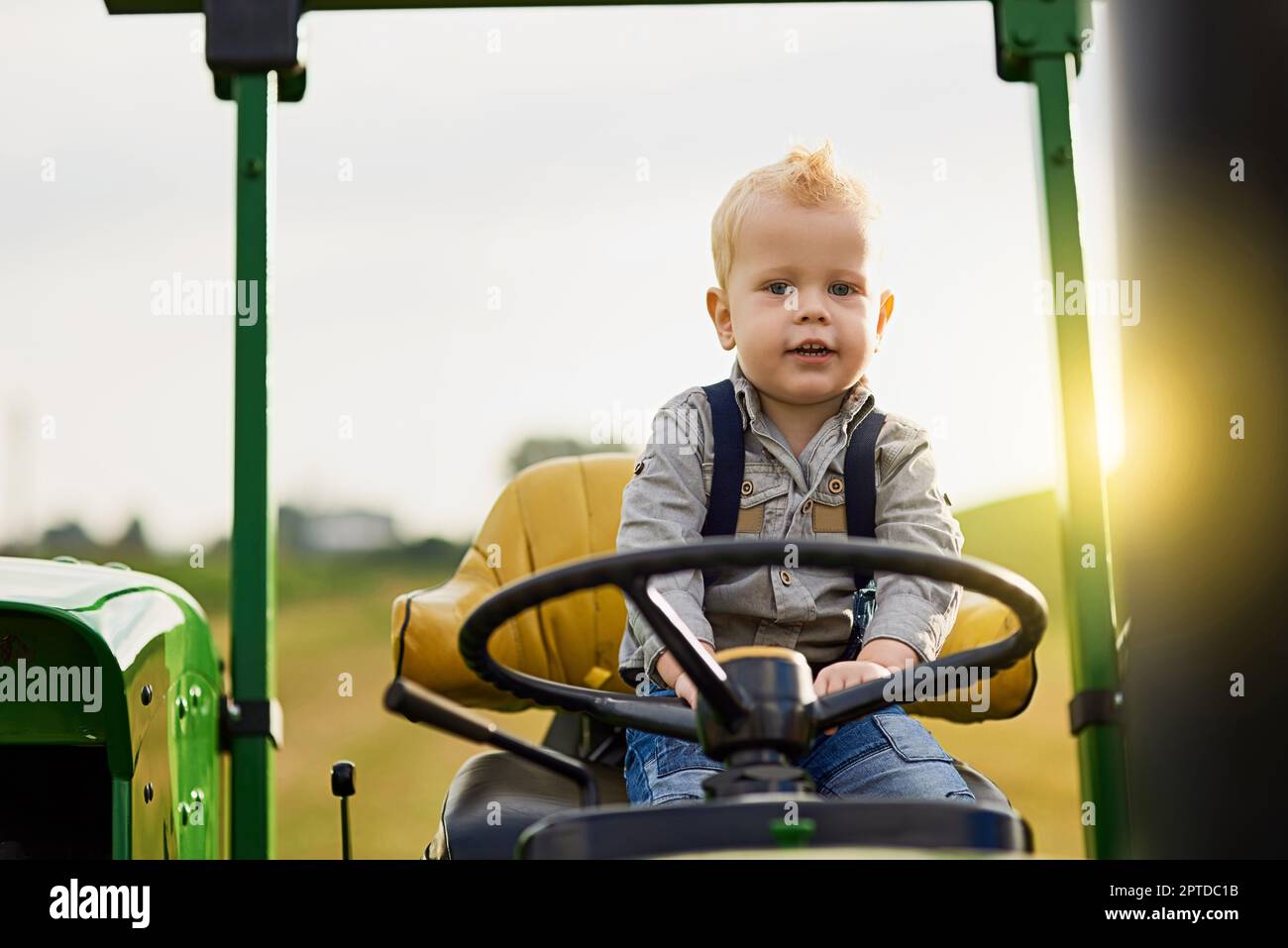 Hes the future of farming. Portrait of an adorable little boy riding a ...