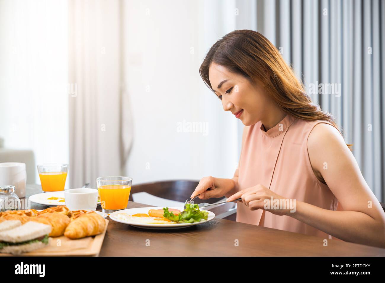 Asian young woman sitting kitchen table food having eating healthy ...