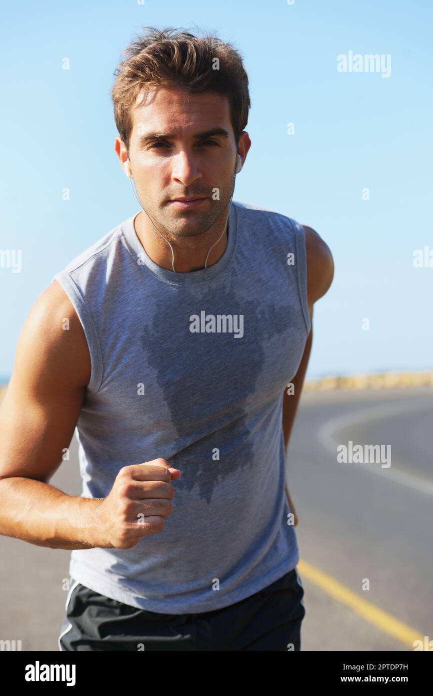 Keeping my body fit and healthy. Handsome young jogger running with a ...