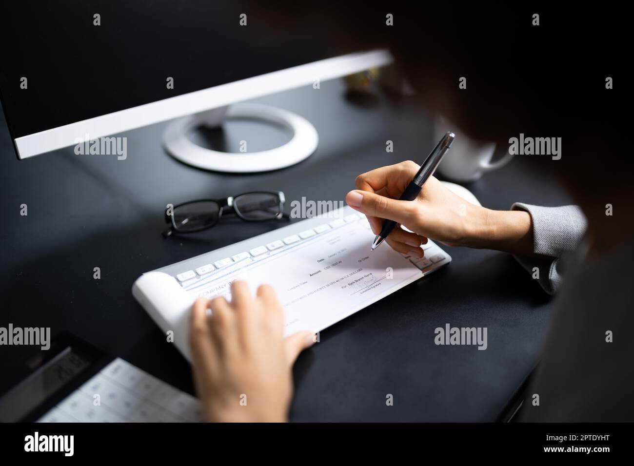 African Woman Signing Bank Check Or Paycheck Stock Photo - Alamy