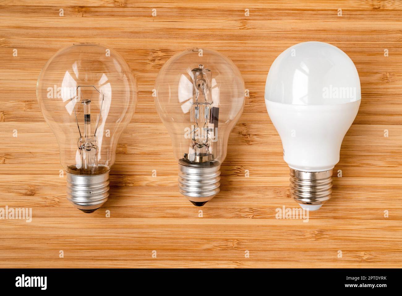 Tungsten bulb,halogen bulb and LED bulb on wooden background. Evolution ...