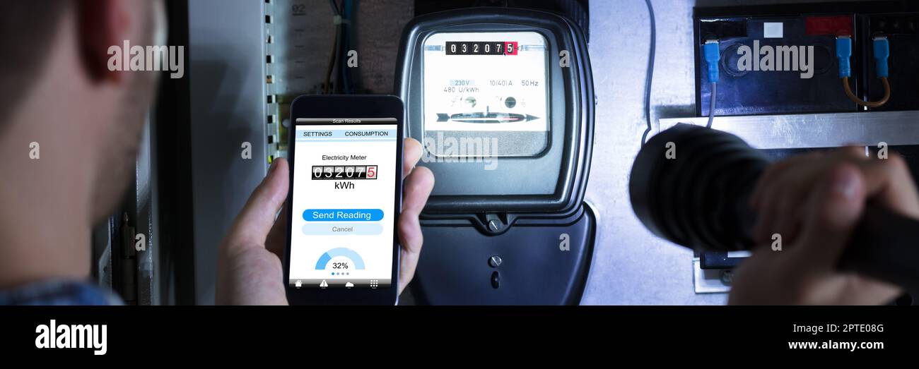 Electrician Reading Energy Meter Using Mobile Phone Stock Photo - Alamy