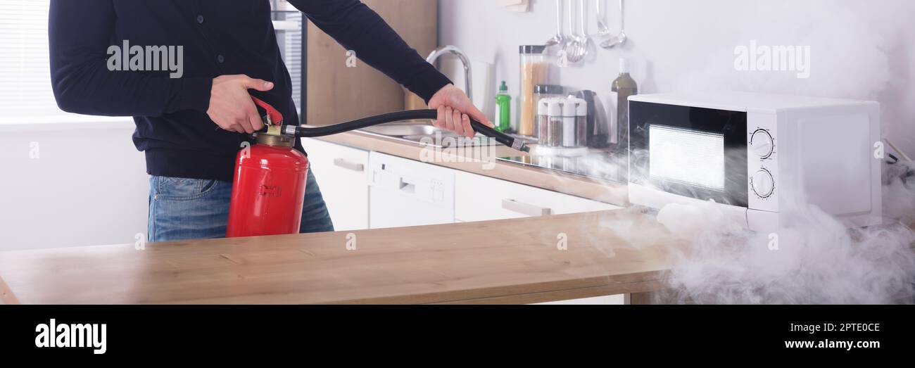 Fire Extinguisher In Kitchen. Microwave Smoke Hazard Stock Photo - Alamy