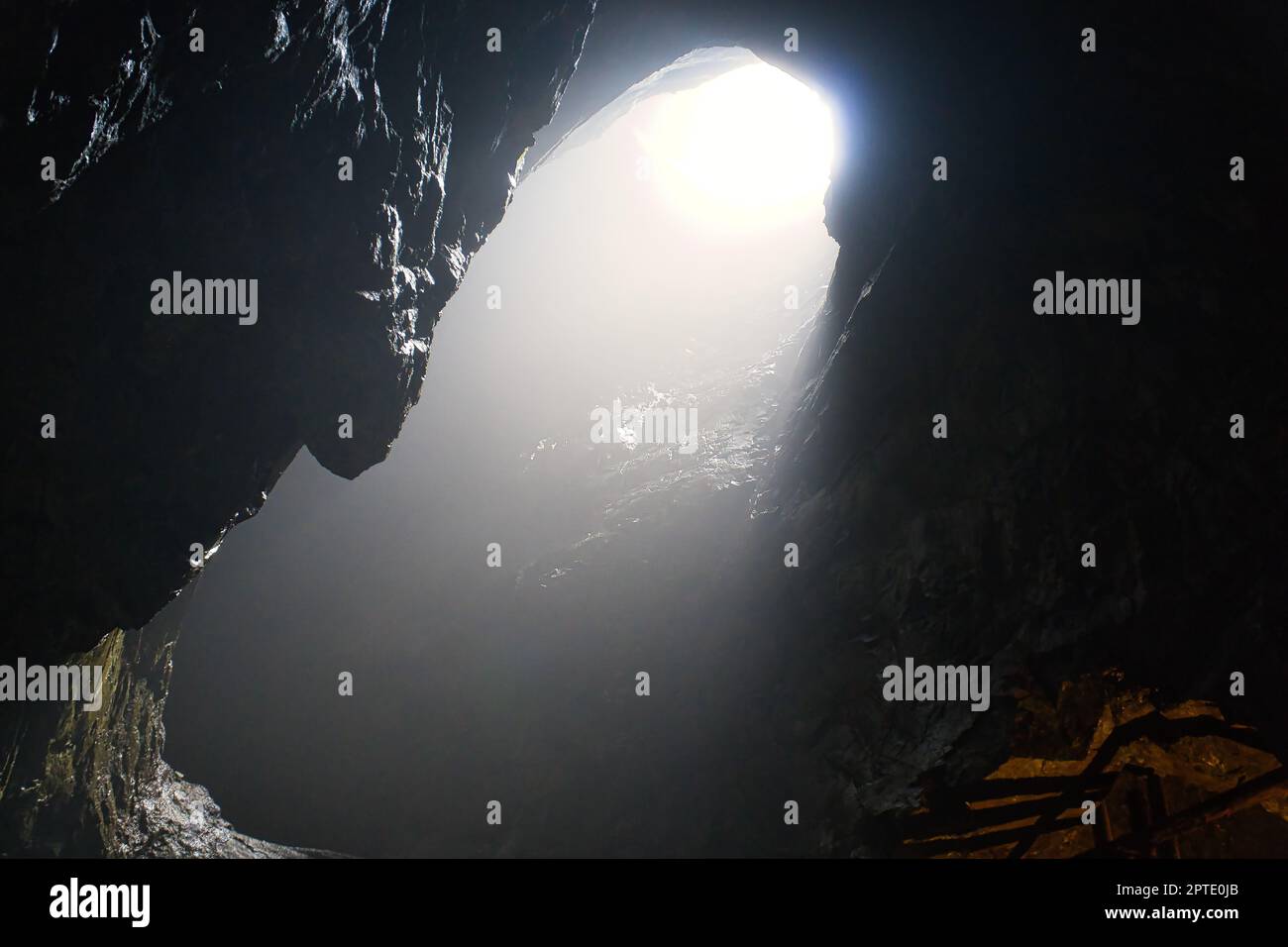 Rock cave with hole through which light shines. Underworlds in Sweden ...