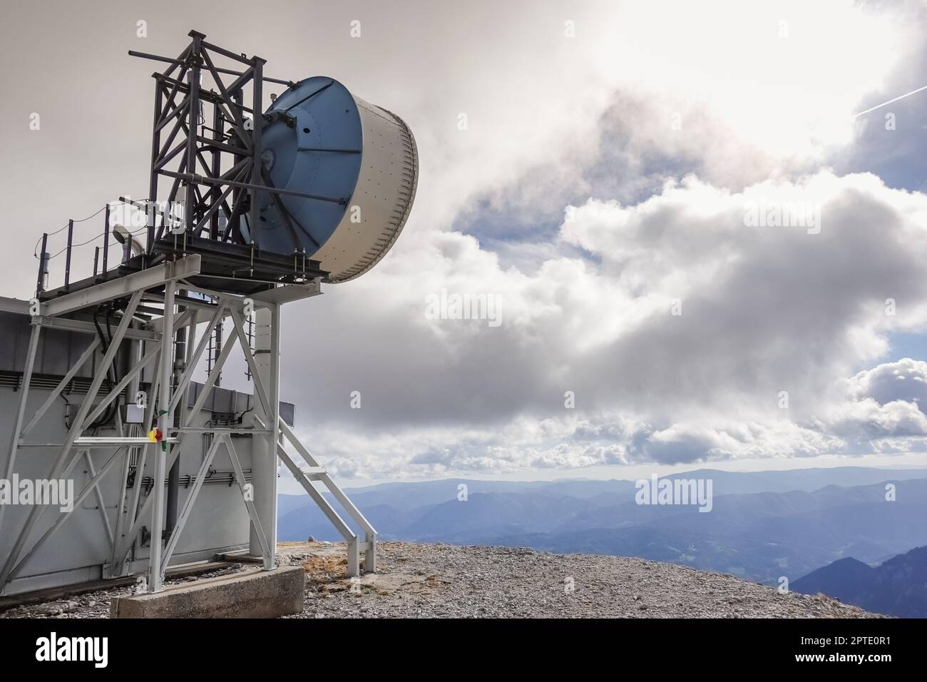 high antennas on the top of a mountain in austria with white clouds on ...