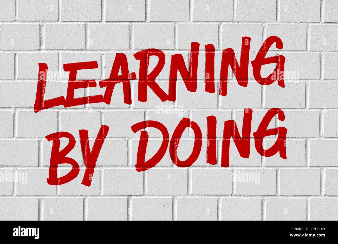 Graffiti on a brick wall - Learning by doing Stock Photo - Alamy