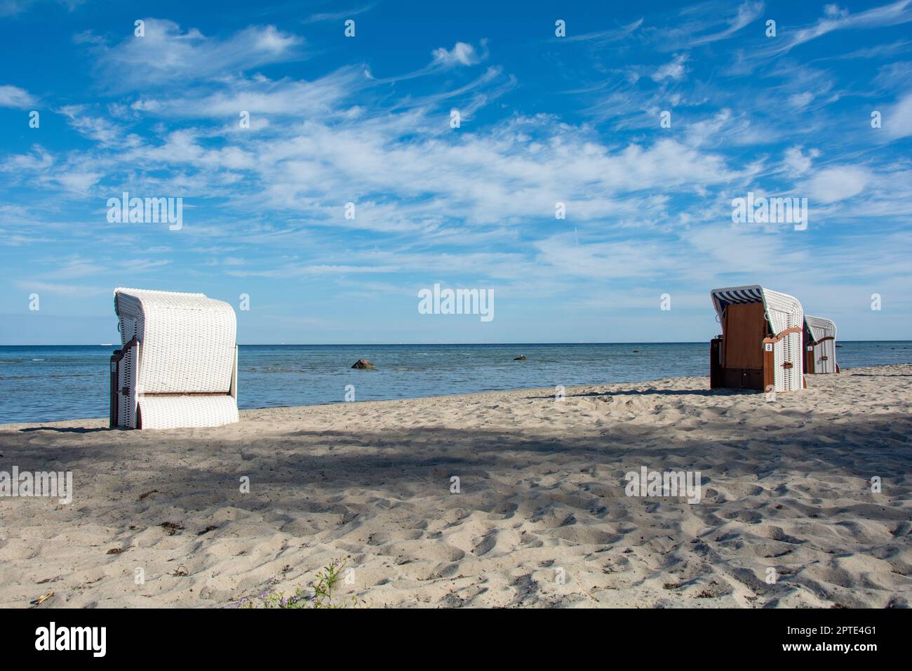 White traditional wicker beach baskets on the sandy beach with the ...