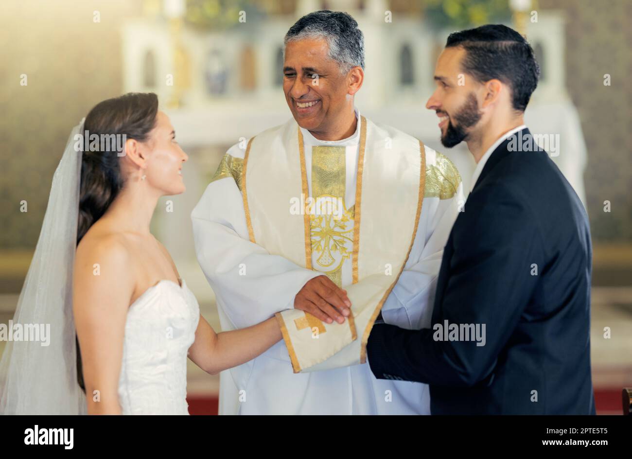 Wedding, priest and couple holding hands in church for a christian ...