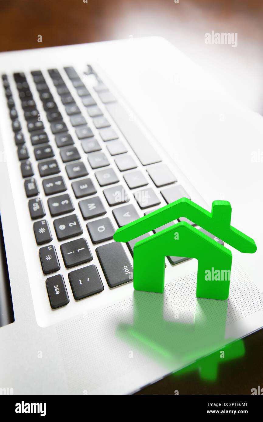 House Icon Resting on Laptop Keyboard Stock Photo - Alamy