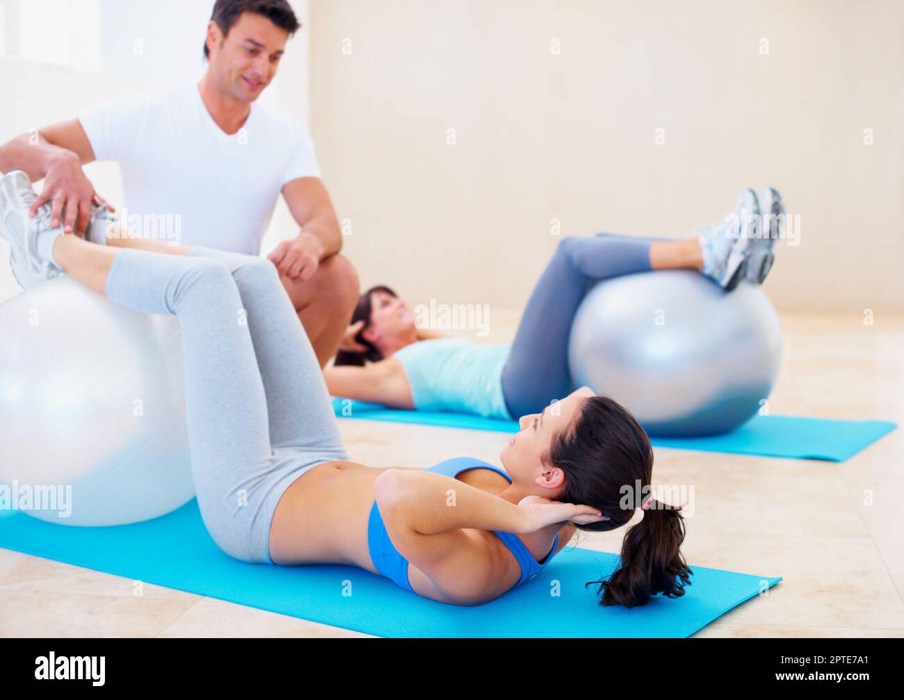 Bring your head up slowly....Young woman doing a sit up during a ...
