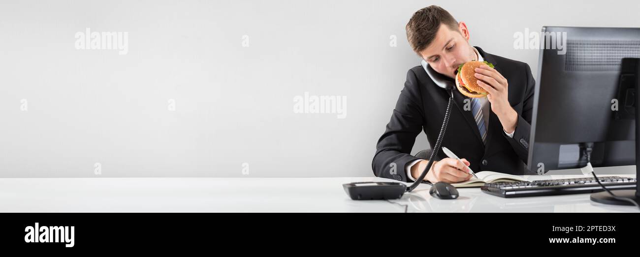 Eating Fat Burger Food In Office. Heavy Stress Stock Photo - Alamy