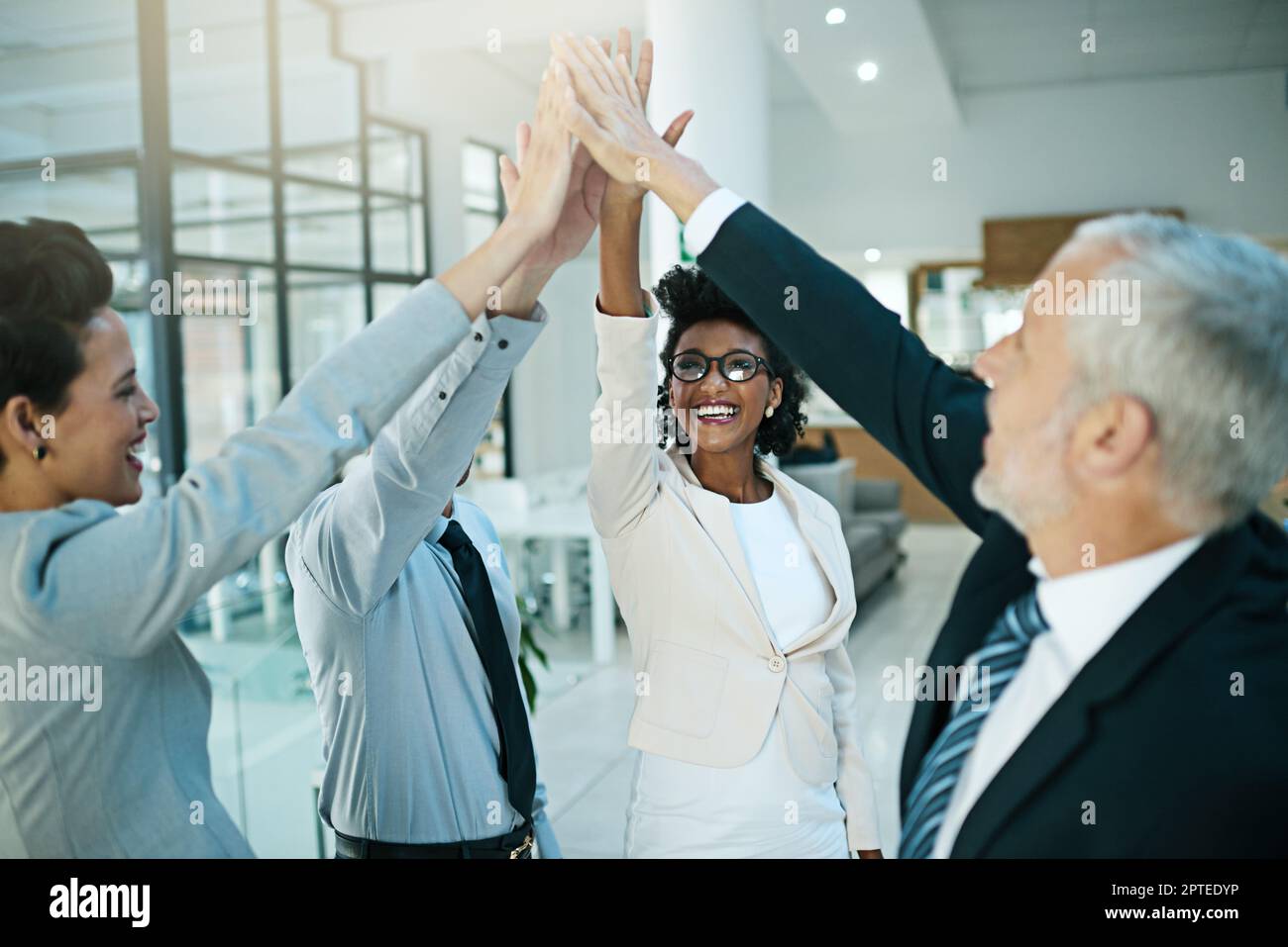 Weve reached success together. a group of colleagues giving each other a high five Stock Photo ...