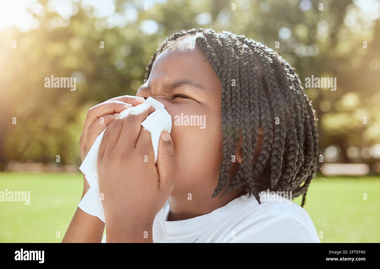 Covid, health and black kid blowing nose at park, nature or outdoors ...