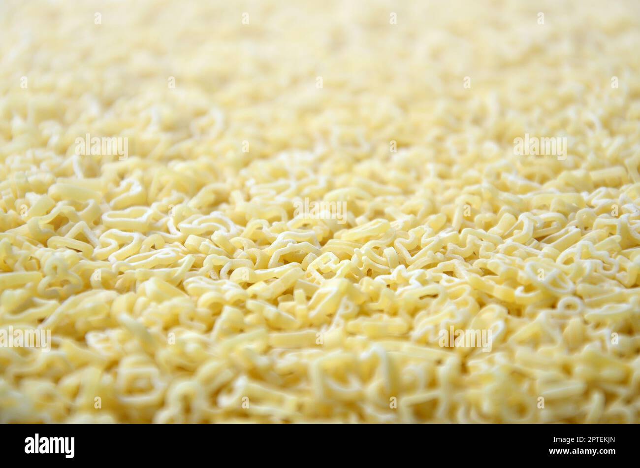 Texture of a lot of curly raw yellow pasta Stock Photo - Alamy