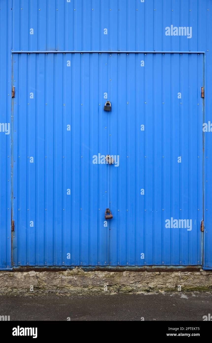 Texture of a metal blue wall with a gate closed for three locks Stock ...