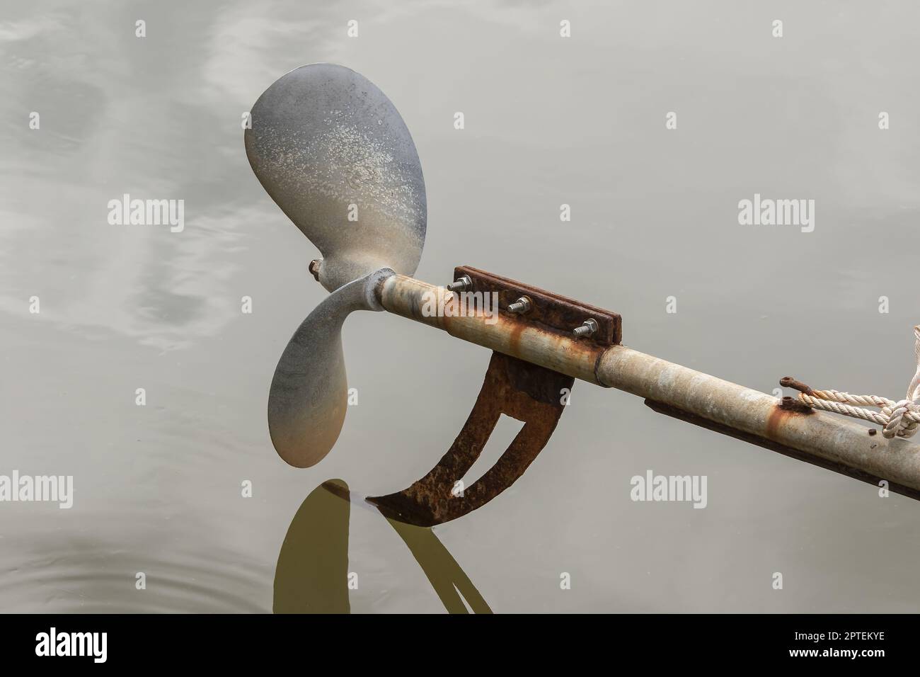 The old long-tailed boat propeller that was rusting was above the water ...
