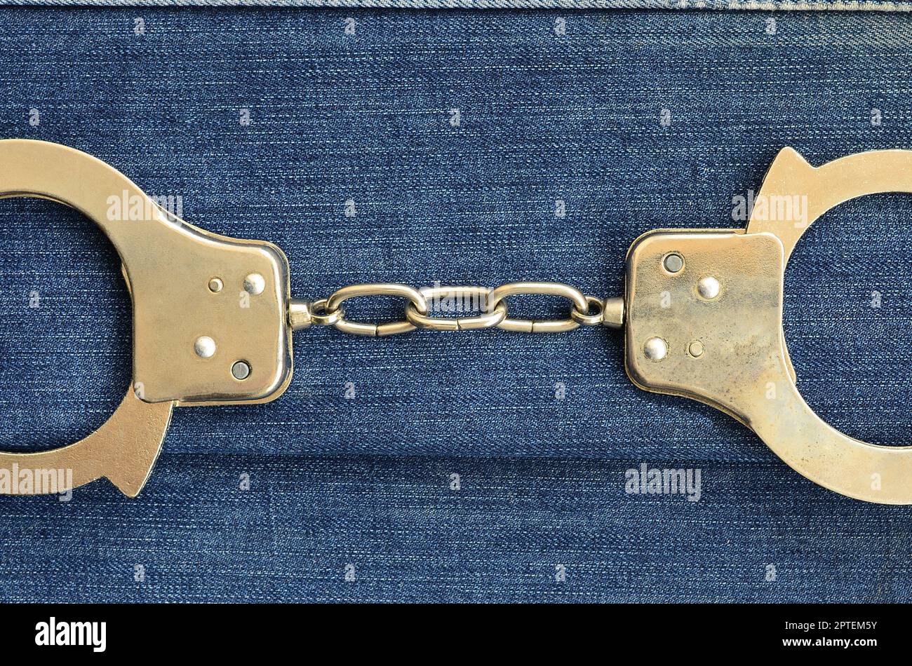 Police steel handcuffs lying on dark blue jeans background Stock Photo ...