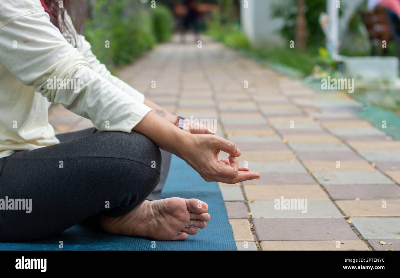 Close up woman mudra hand gesture doing yoga relaxing in lotus position ...