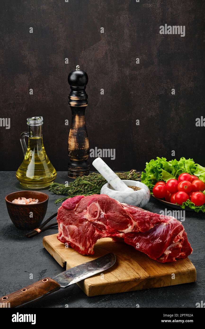 Overhead view of raw lamb rump on wooden cutting board (photo with full ...