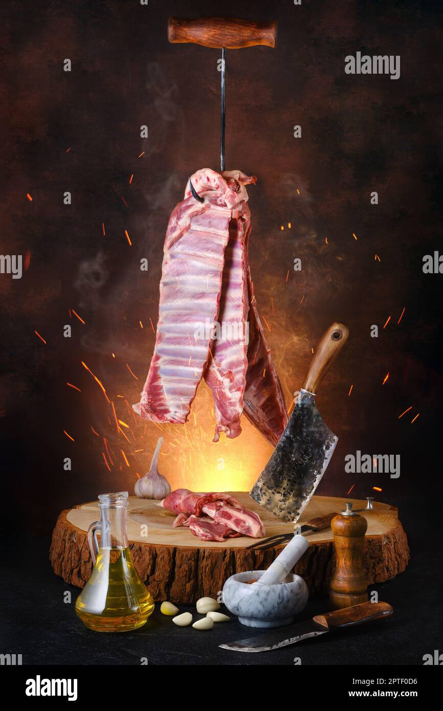 Poster with raw lamb ribs on hook over wooden stumb Stock Photo - Alamy