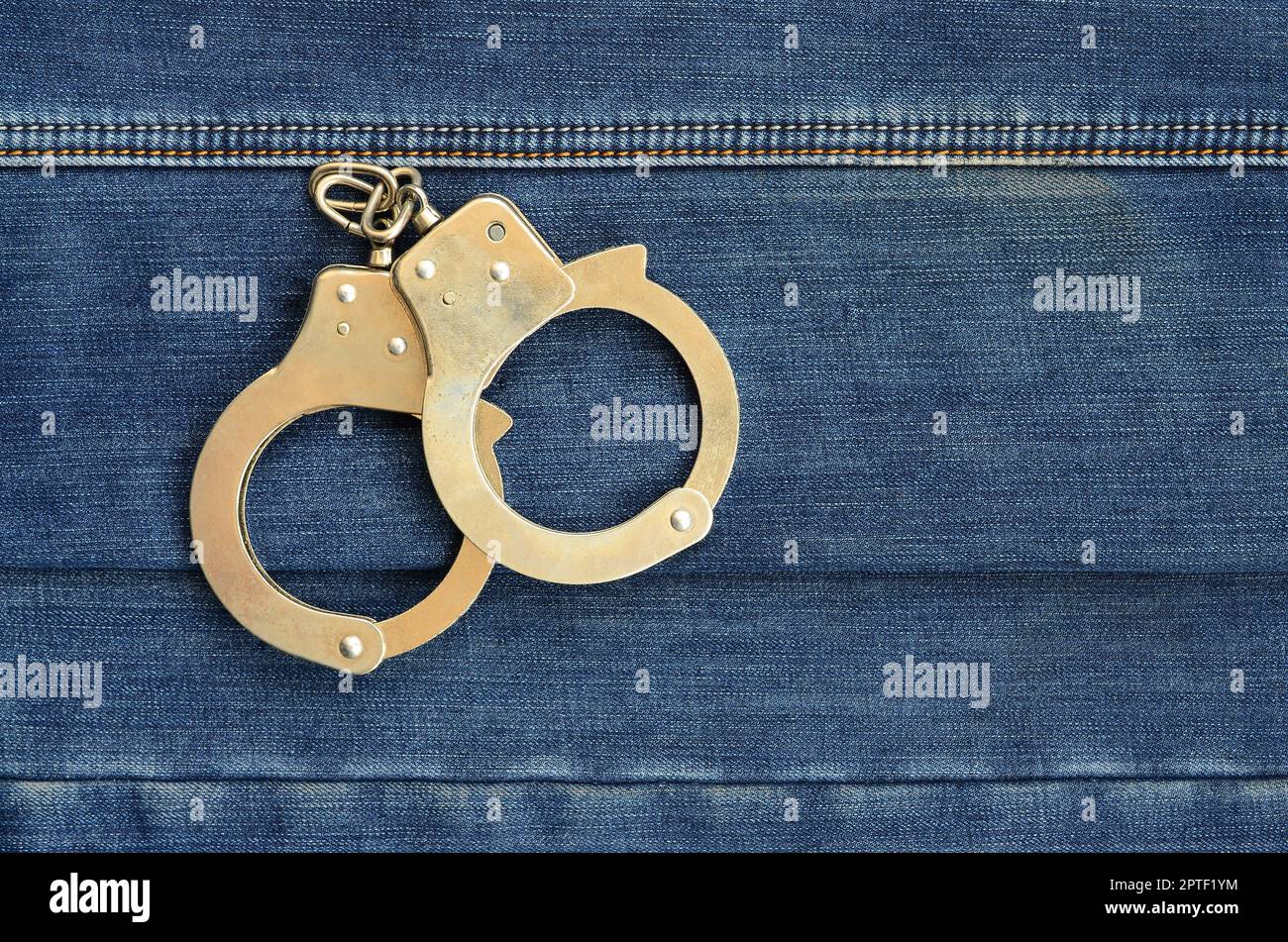 Police steel handcuffs lying on dark blue jeans background Stock Photo ...