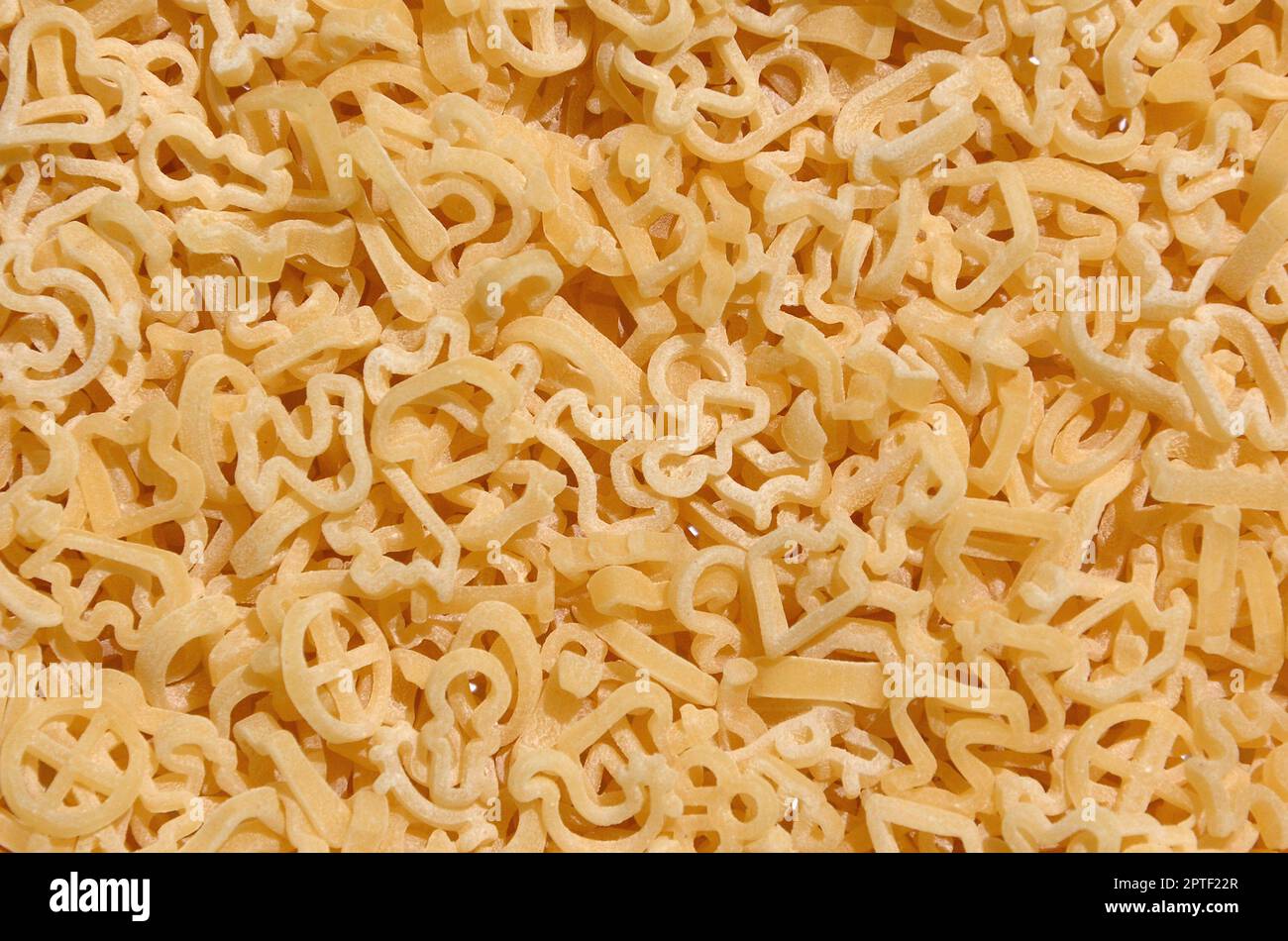 Texture of a lot of curly raw yellow pasta Stock Photo - Alamy
