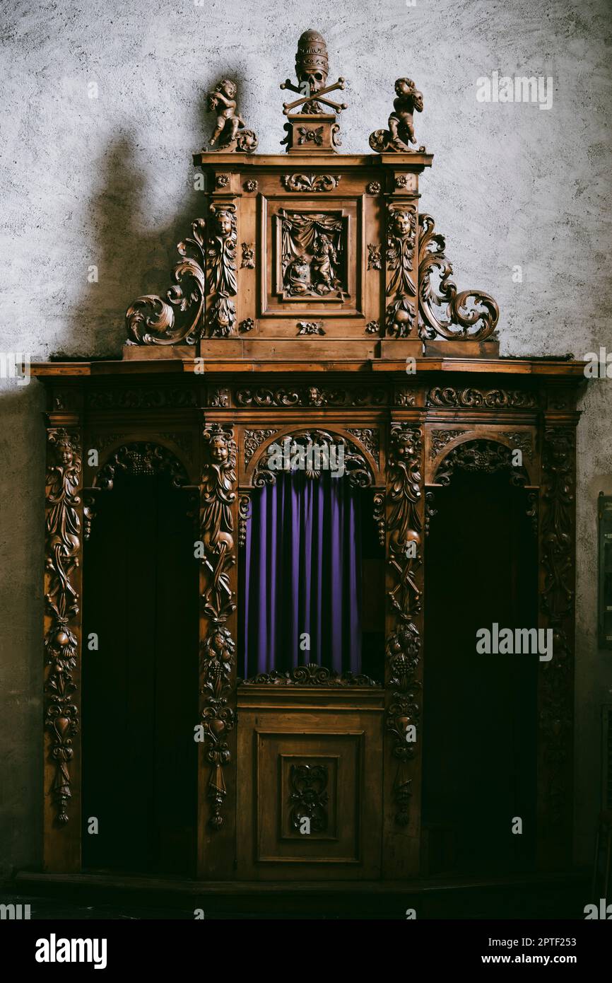 Typical old wooden confession booth at a church, with blue curtains ...