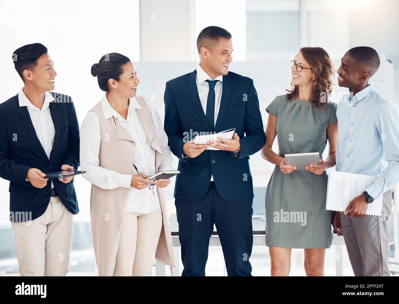 Team, leadership and business people standing in office talking, having ...