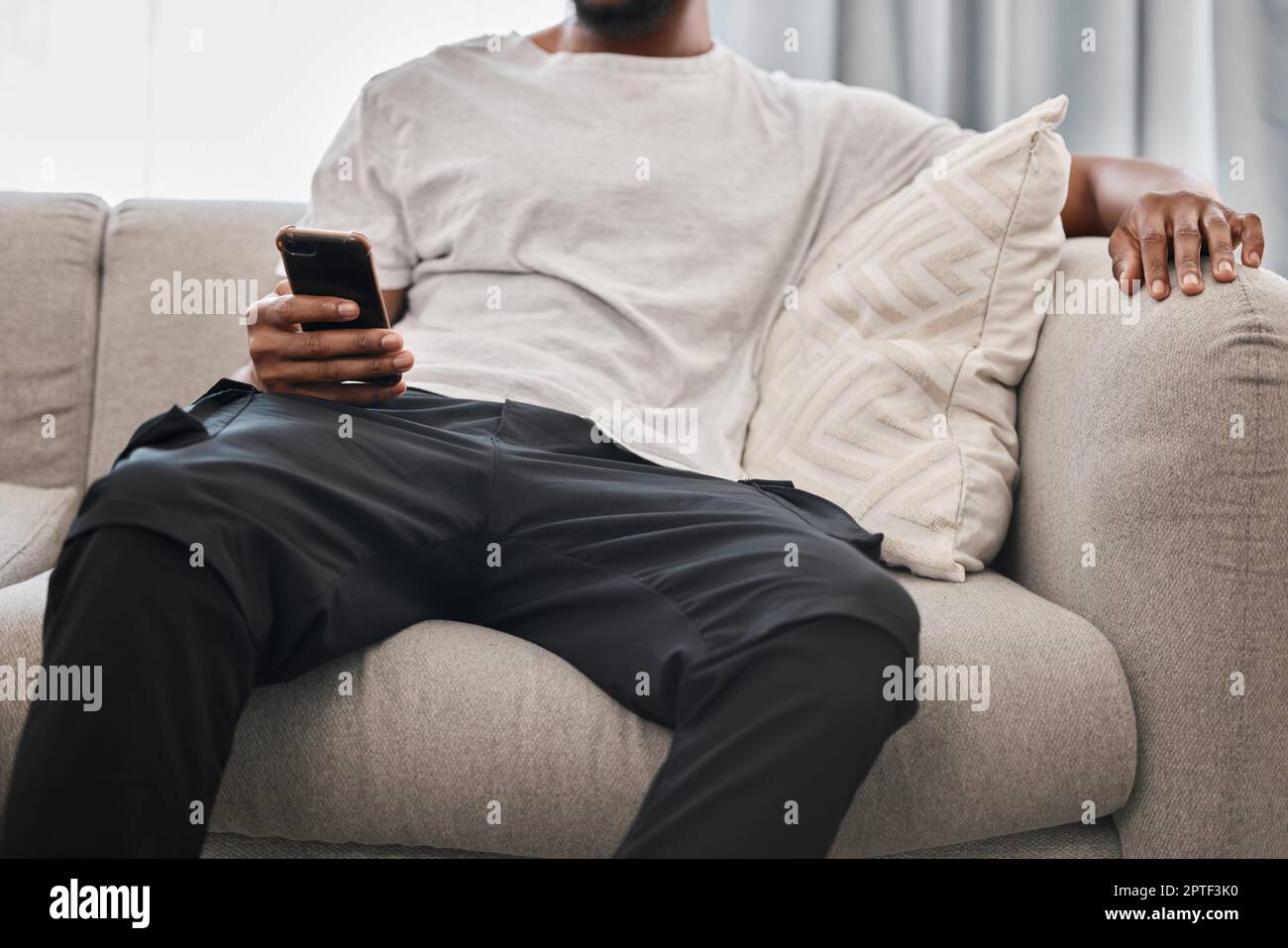 Social media, relax and man on the sofa with a phone for communication ...