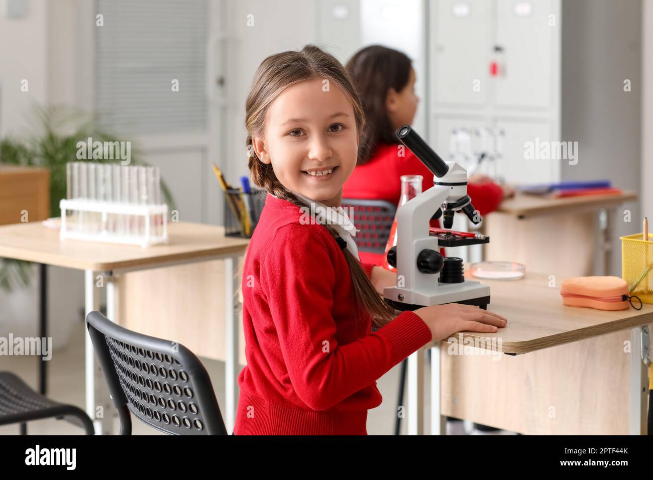 Little girl with microscope having Chemistry lesson in science ...