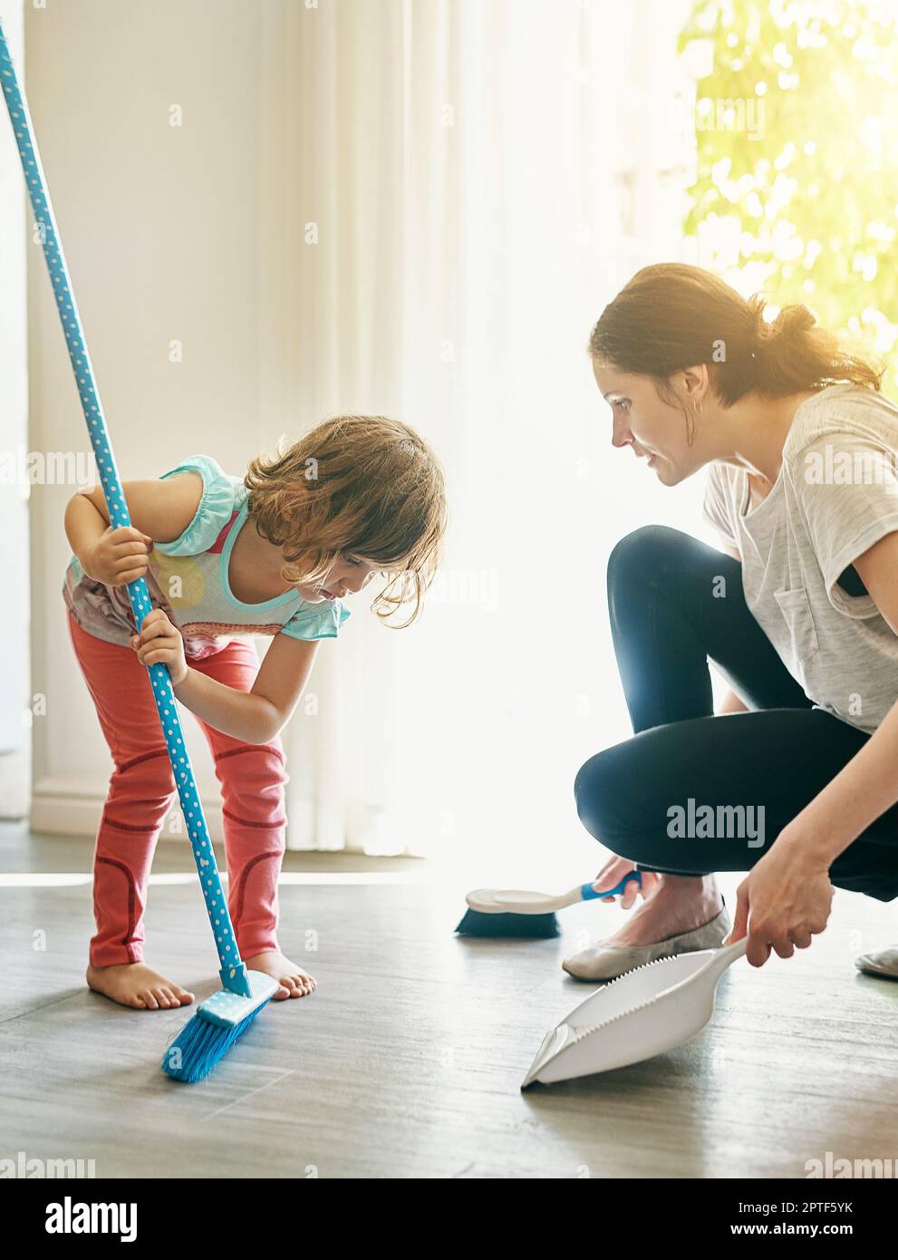 Child sweeping with mother hi-res stock photography and images - Alamy