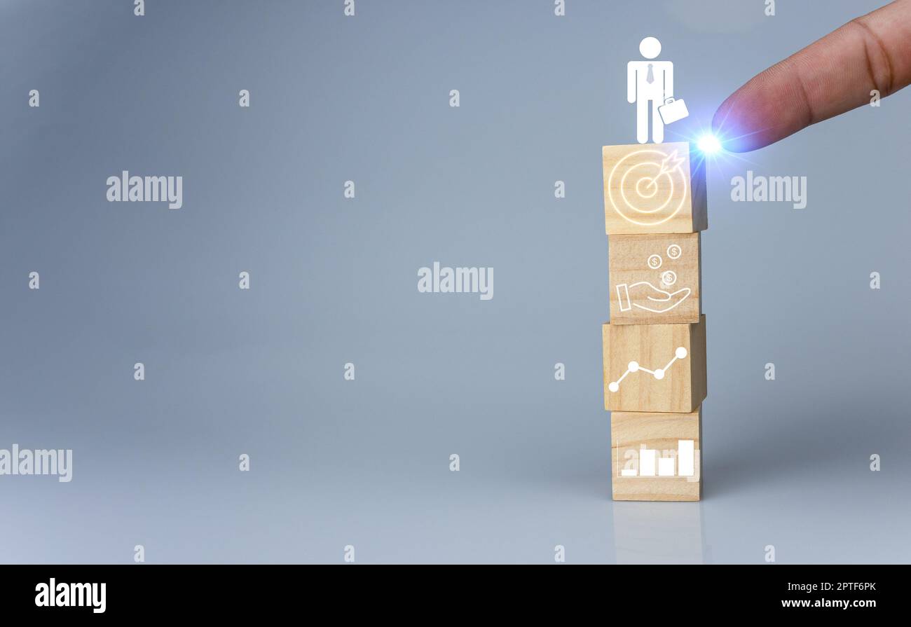 Hand pointing at one wood cube block with target icon . Concept of business strategy and goal ...