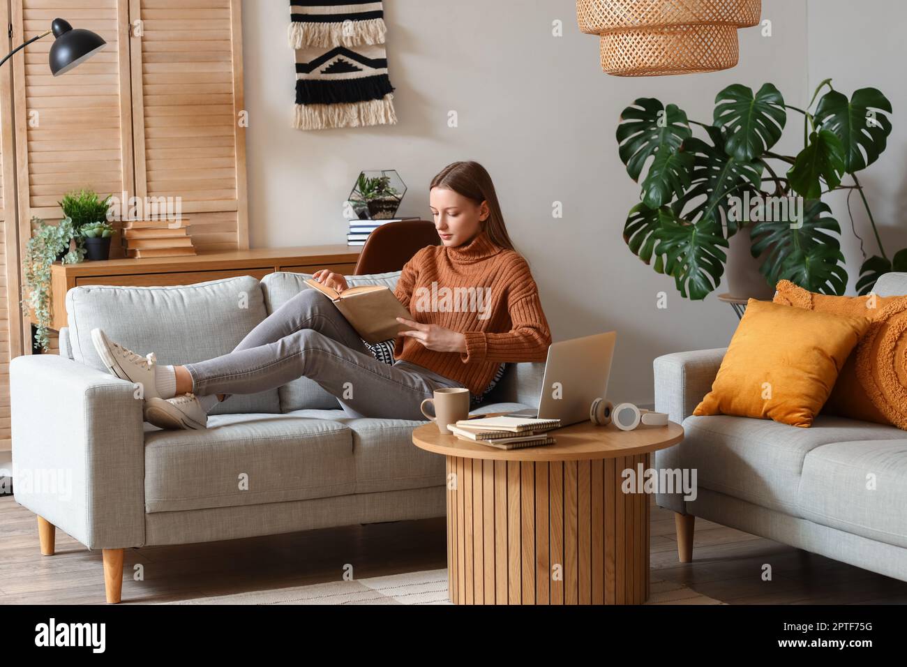 Female student reading book at home Stock Photo - Alamy