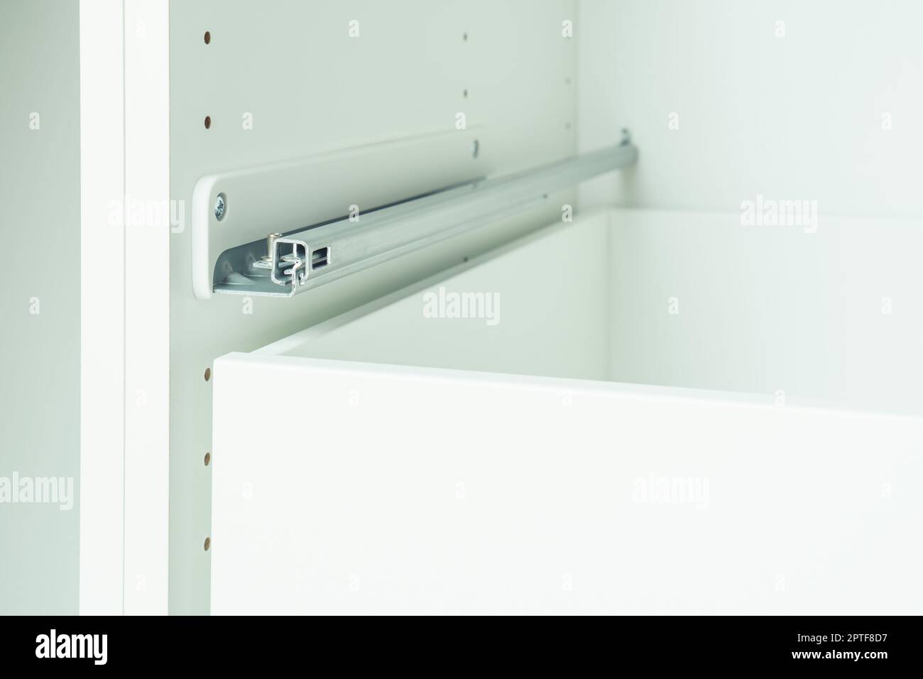 Drawer rail inserted into cabinet, fixed with self-tapping screws ...