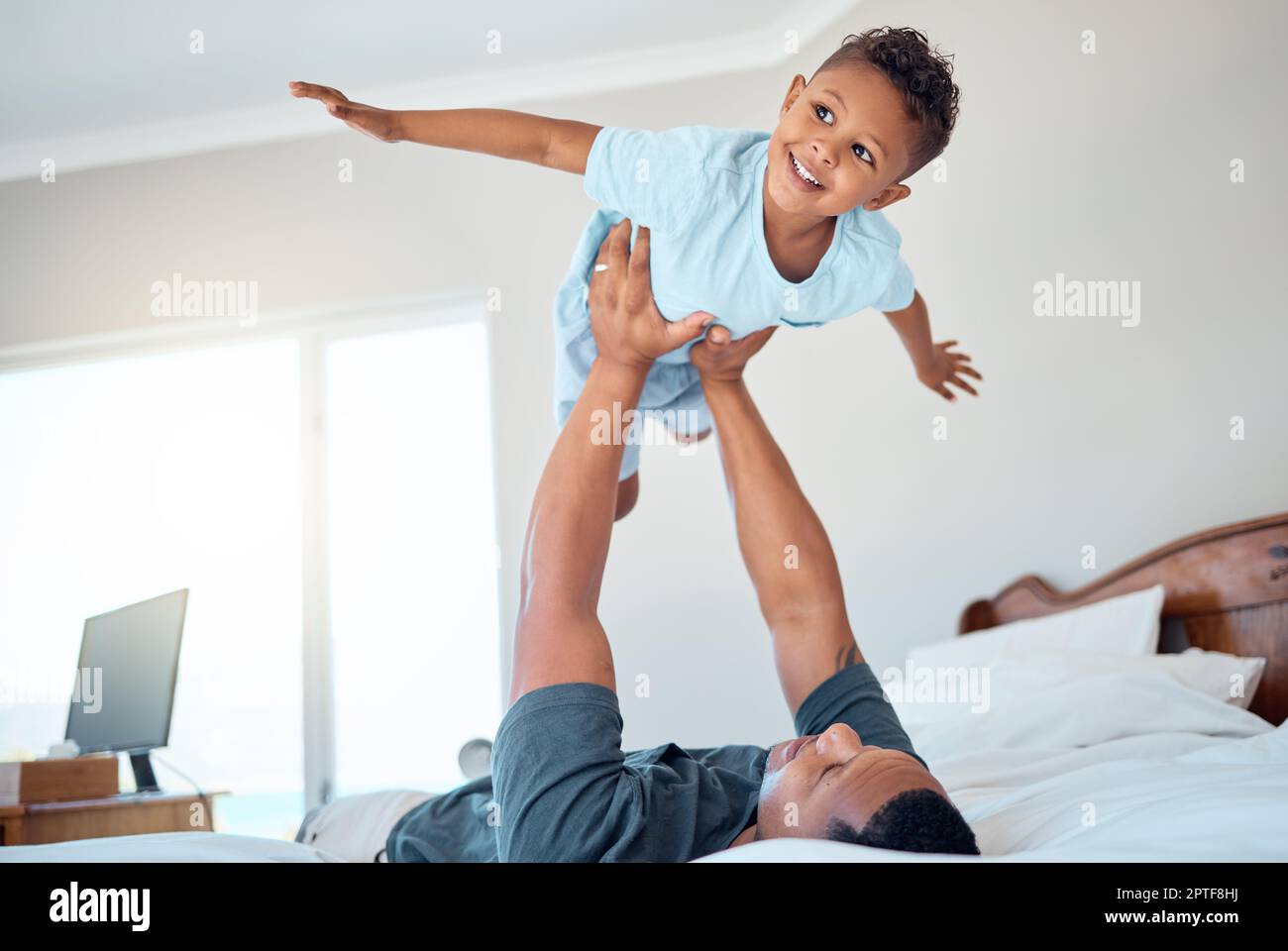 Father lifting kid in air in the bedroom having fun, playing and ...