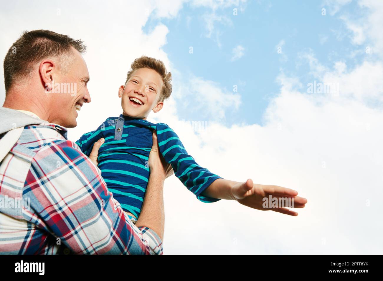 His son means the world to him. a dad standing outside holding his son ...