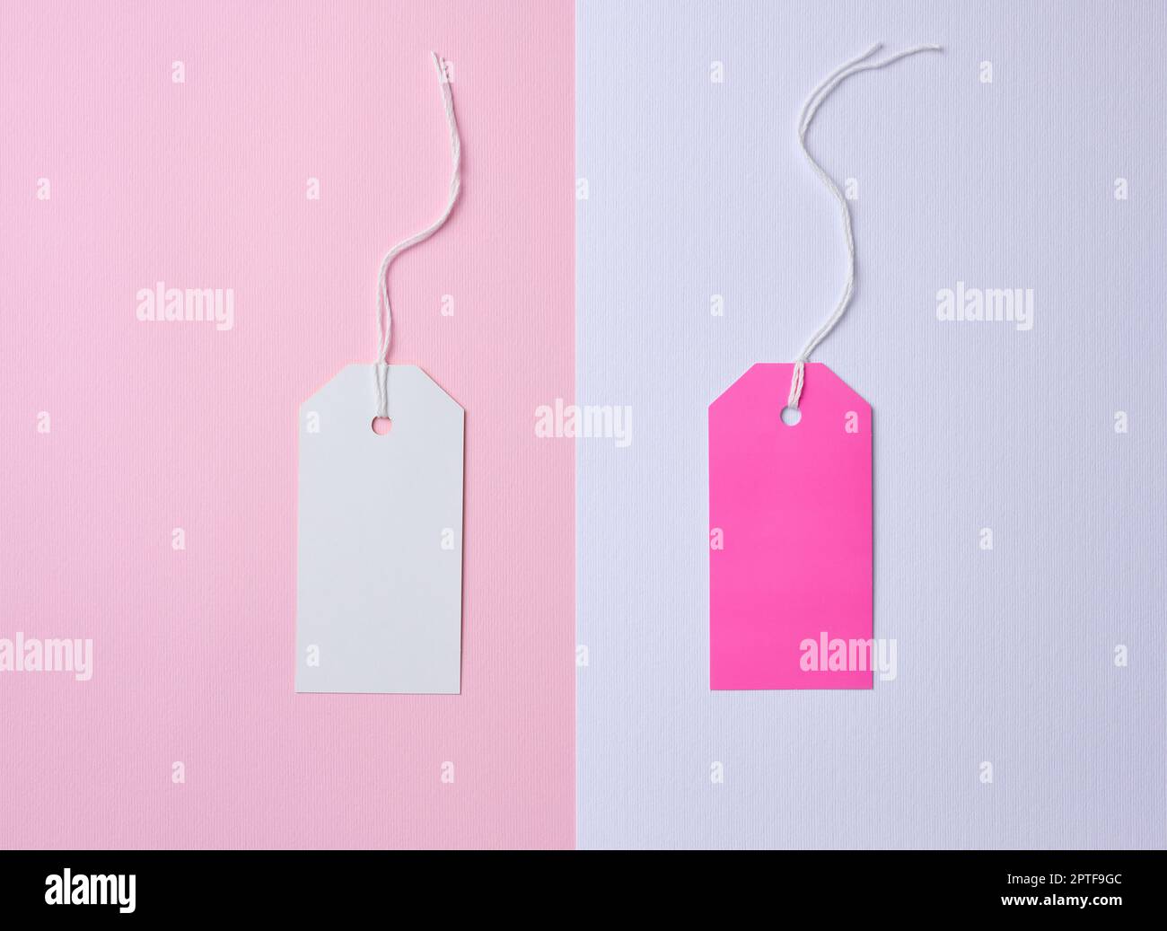 Empty white and pink cardboard tag on a white rope, pink background ...