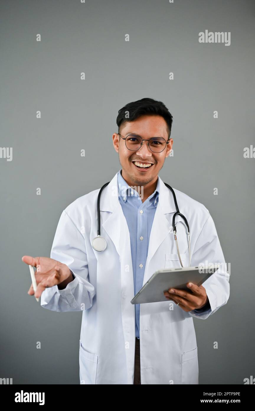 Smart and handsome millennial Asian male doctor in a uniform holding a ...