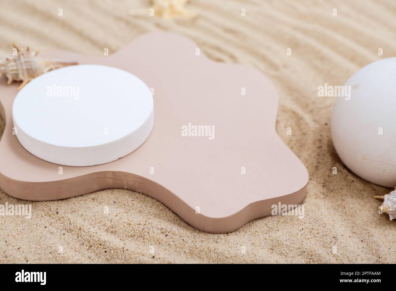 Decorative plaster podiums and seashell in sand Stock Photo - Alamy