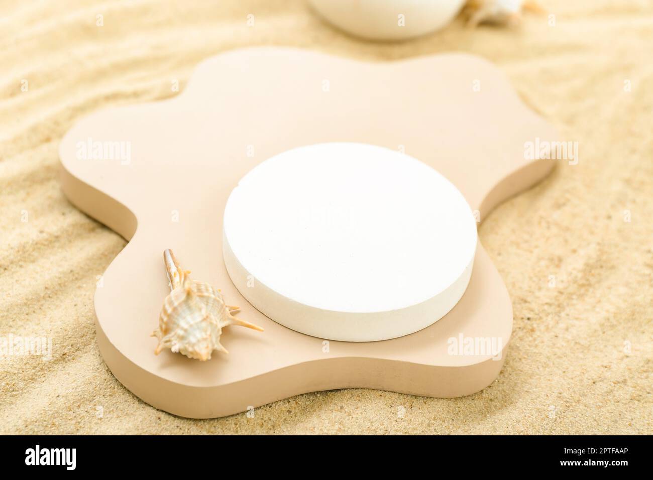 Decorative plaster podiums and seashell in sand Stock Photo - Alamy