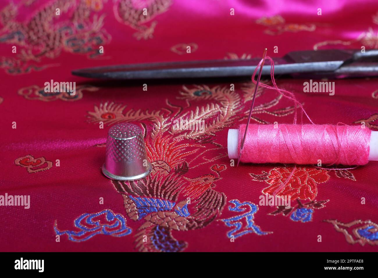 Spool of Pink Thread and Thimble on Vintage Pink Satin Stock Photo - Alamy