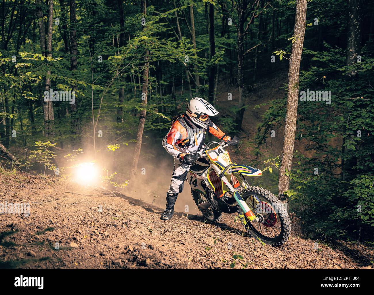 Extreme rider climbing rocky hill in the forest on off-road enduro ...