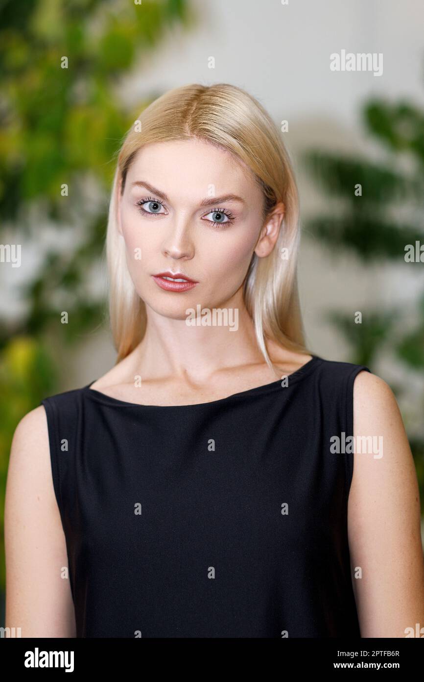 Portrait of beautiful calm girl in sleeveless dress standing still and ...