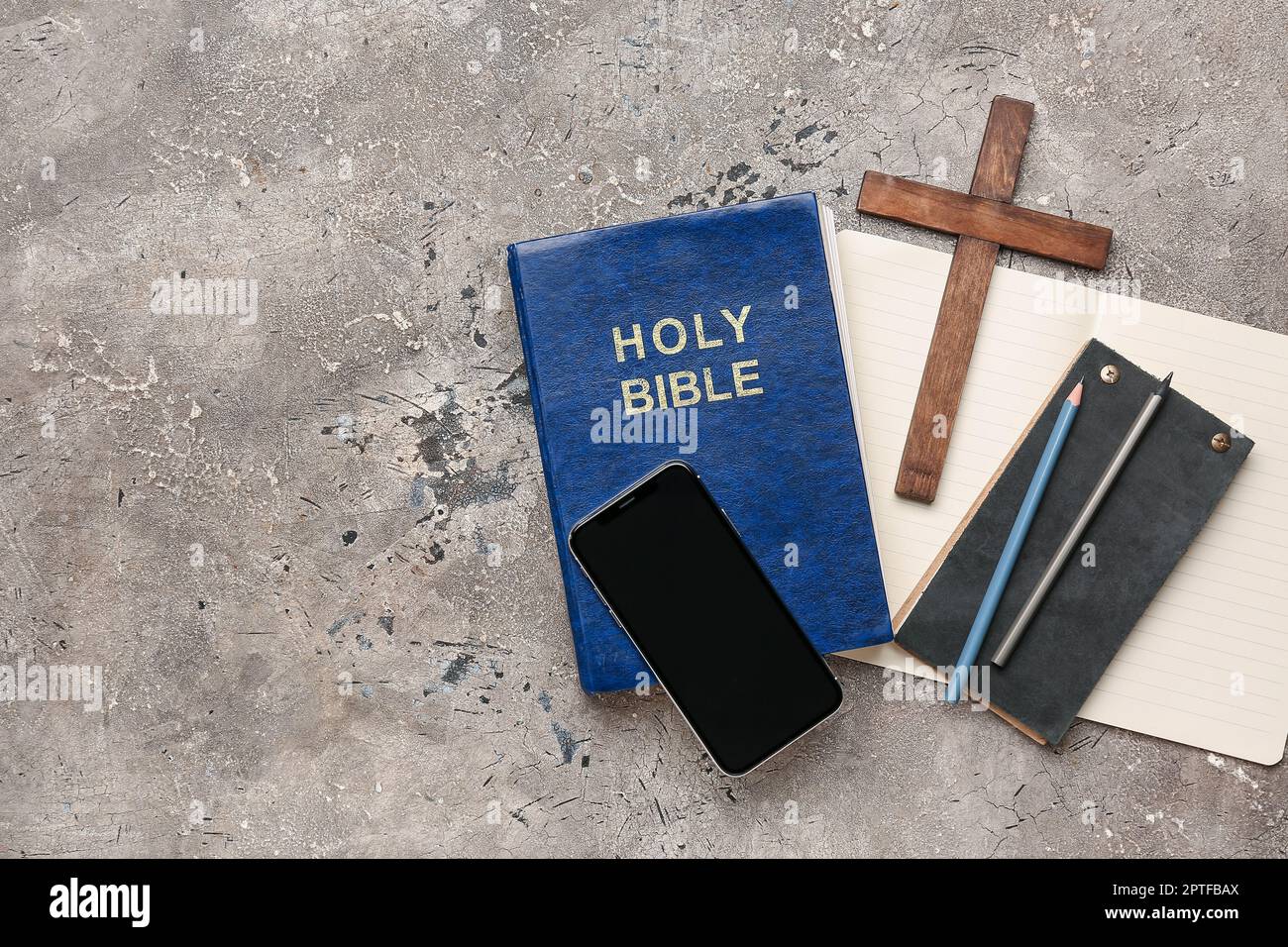 Holy Bible with mobile phone, notebooks and cross on grunge background ...