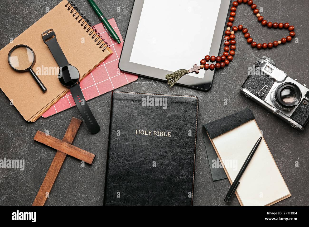 Holy Bible with prayer beads, notebooks, tablet computer, smartwatch ...