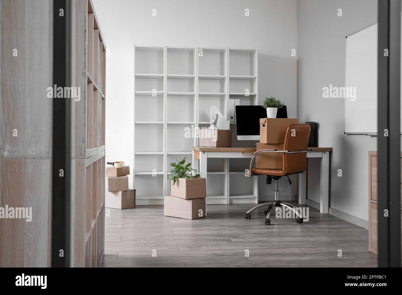 Workplace with cardboard boxes in office on moving day, view through ...