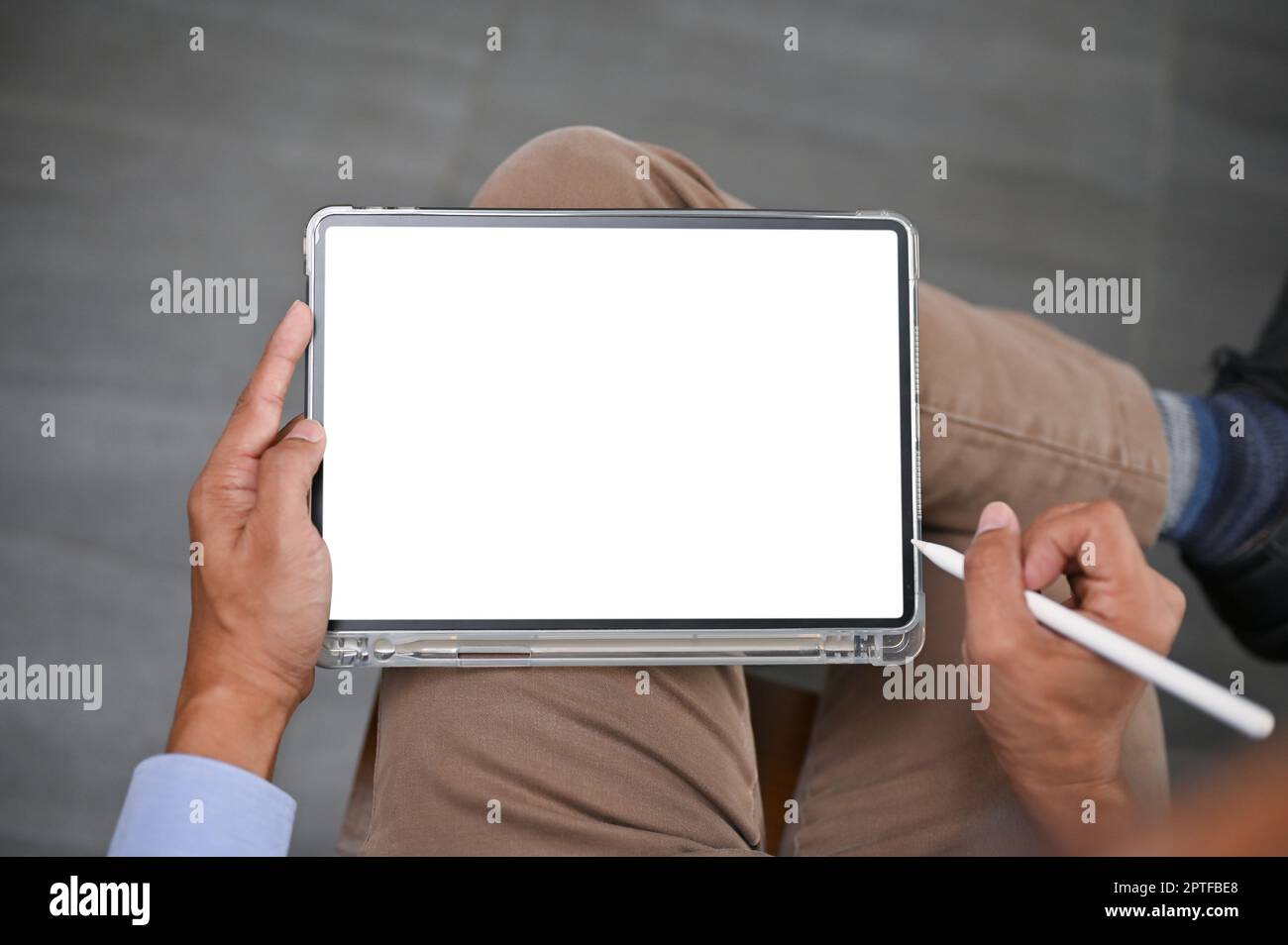 Top view image of an Asian man using his digital tablet in a room. Digital tablet white screen ...