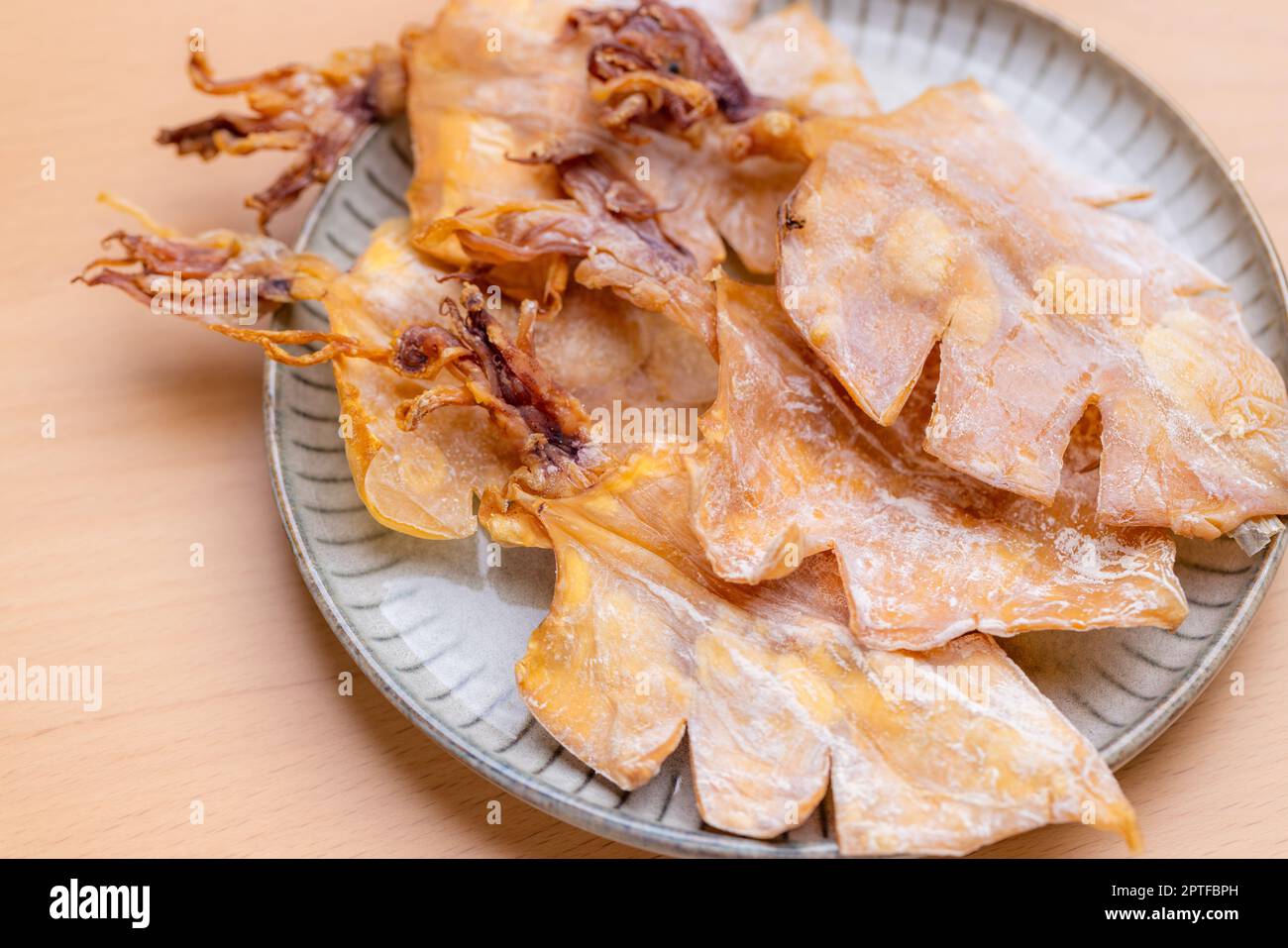 Dried squid snack in the plate Stock Photo - Alamy