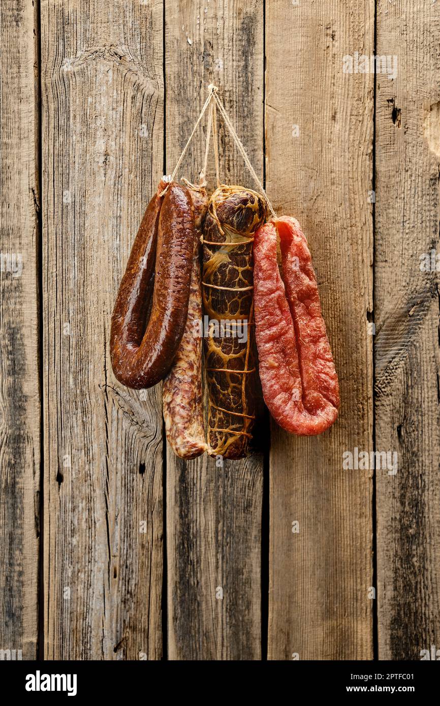 Assortment of dried meat and sausages hanging on a barn wall Stock ...
